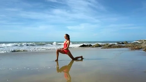 Waves Roll on Beach to Girl in Yoga Pose... | Stock Video | Pond5