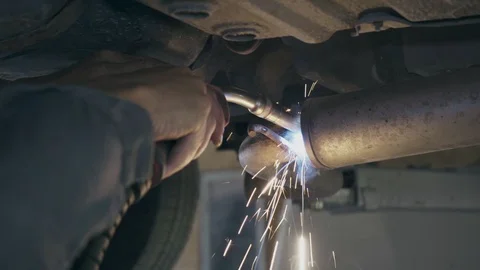 Welder welds car exhaust pipe | Stock Video | Pond5
