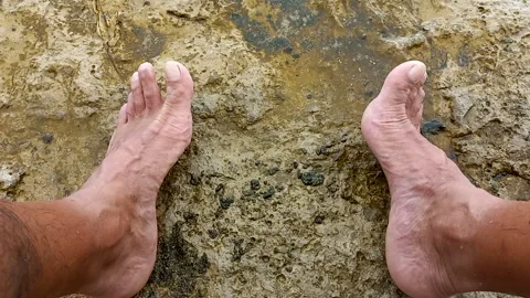 Wet, bare feet of a man standing on rock... | Stock Video | Pond5