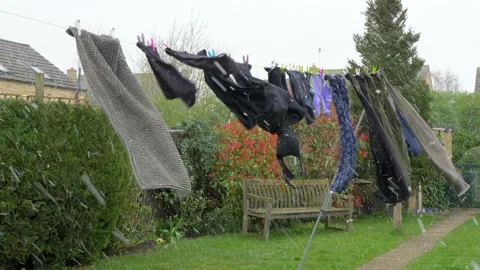 Wet washing blowing on a line in a garde... | Stock Video | Pond5