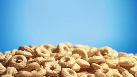 Wheat cereal rings falling on blue backg... | Stock Video | Pond5