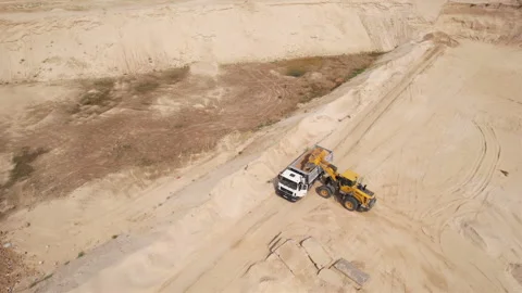 Wheel loader loading sand into dump truc... | Stock Video | Pond5