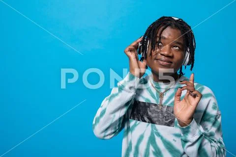 Photograph: While listening to music, a dark-skinned student looks up ...
