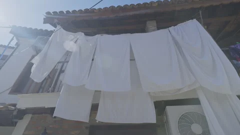 White bedding and towels hanging on rope... | Stock Video | Pond5