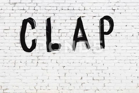 White brick wall with inscription clap handwritten with black paint ...