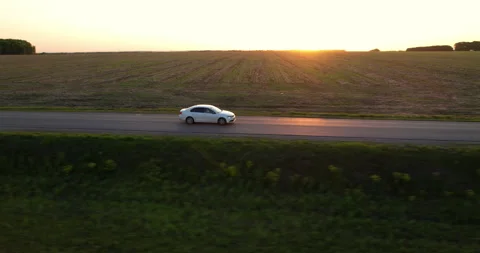 A white car is driving straight on an as... | Stock Video | Pond5