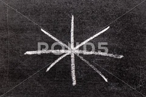 White chalk hand drawing in asterisk shape on black board background ...