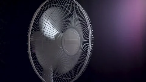 White electric fan on a dark background.... | Stock Video | Pond5