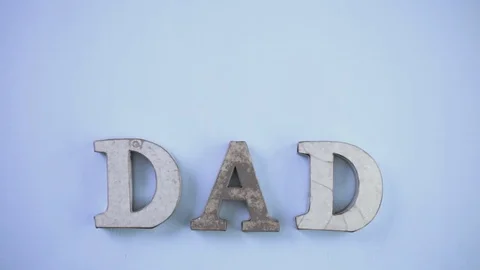 White letters DAD on a painted wood back... | Stock Video | Pond5
