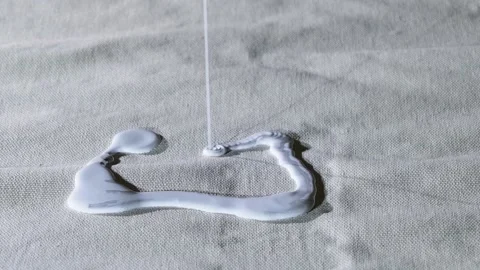 white paint spills onto fabric | Stock Video | Pond5