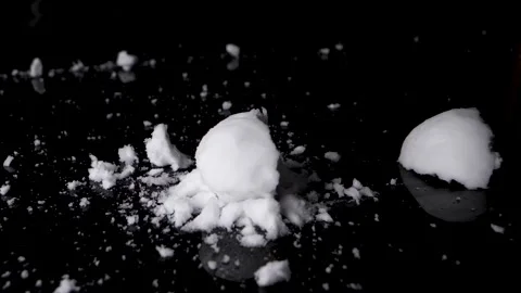 White snowball smashing on black surface... | Stock Video | Pond5