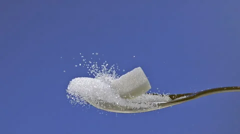 White Sugar Cube falling against Blue Ba... | Stock Video | Pond5
