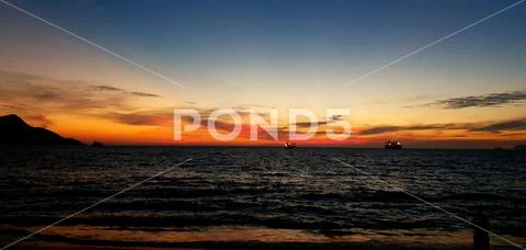 Wide shot of the ocean captured at the beautiful and colorful sunset ...