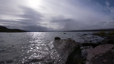 Wide shot of water lapping at rocks in l... | Stock Video | Pond5