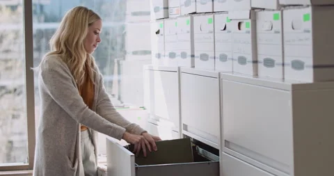 Wide shot of a woman unpacking files out... | Stock Video | Pond5