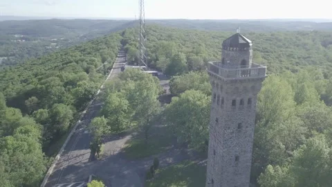 wide view of a stone tower amongst trees | Stock Video | Pond5