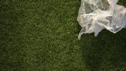 Wind rolling plastic packing on grass, d... | Stock Video | Pond5
