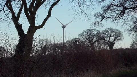 Wind turbine turns in breeze surrounded ... | Stock Video | Pond5