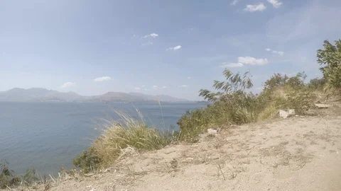 Windy view of a cliff with ocean, mounta... | Stock Video | Pond5
