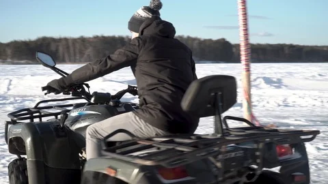 In winter, a young man riding an ATV ent... | Stock Video | Pond5