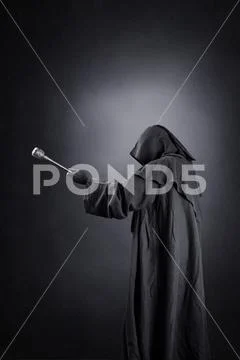 Photograph: Wizard with hooded cape and magic staff over dark misty ...