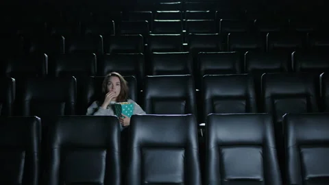 Woman alone in the cinema hall at the pr... | Stock Video | Pond5