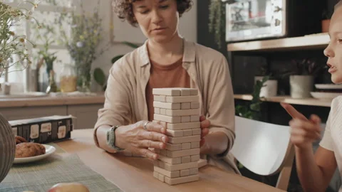 Woman And Kid Building Tower For Board G... | Stock Video | Pond5