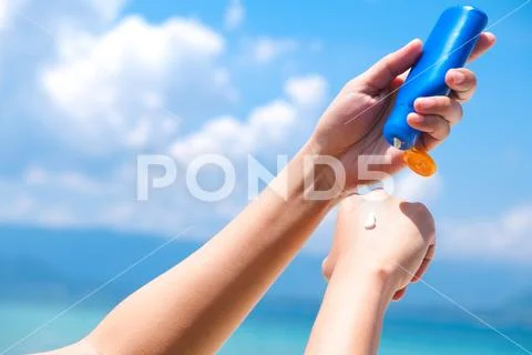 A woman is applying sunscreen and skin care to protect her skin from UV ...