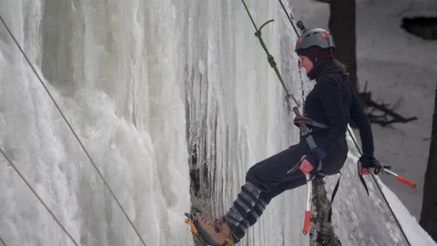 A woman with axes and crampons repelling... | Stock Video | Pond5