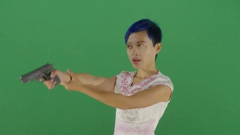 woman backwards pointing a gun to green ... | Stock Video | Pond5