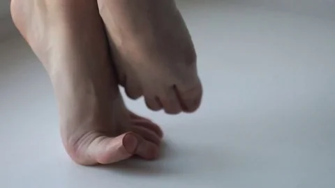 Woman bare feet standing on toes on whit... | Stock Video | Pond5