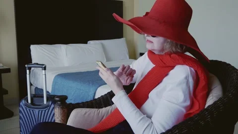 Woman in big red hat with suitcase check... | Stock Video | Pond5