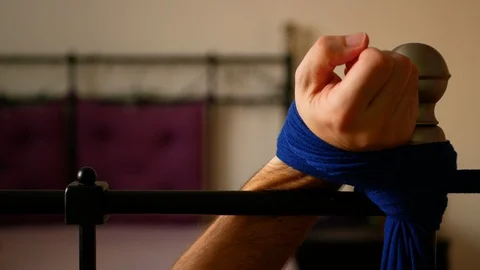 Woman binding male hands to bed | Stock Video | Pond5