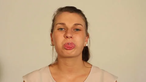 Woman blowing a raspberry at the camera | Stock Video | Pond5