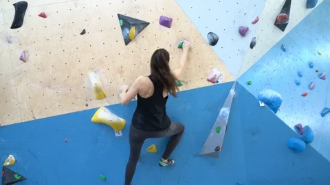 Woman bouldering up a wall in an indoor ... | Stock Video | Pond5