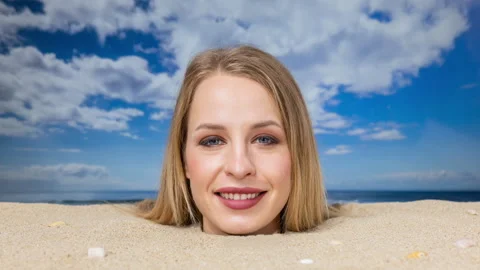 Woman buried in sand on beach | Stock Video | Pond5