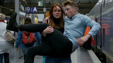 Woman Carrying Man Across Train Platform | Stock Video | Pond5