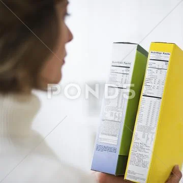 Woman comparing nutrition labels ~ Premium Photo #27882329