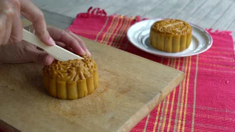 Woman cut a mooncake into half. Mid-autu... | Stock Video | Pond5