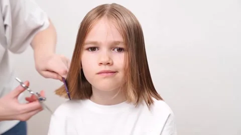 woman does haircut of a sad funny girl o... | Stock Video | Pond5
