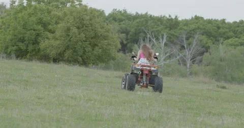 Woman driving a 4 wheeler ATV. The all-t... | Stock Video | Pond5