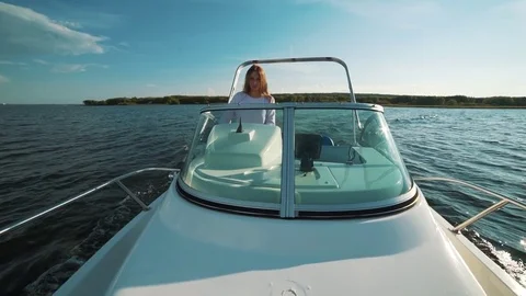 A woman is driving a boat. Hair in the w... | Stock Video | Pond5