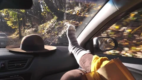 Woman in driving car with legs on dashbo... | Stock Video | Pond5