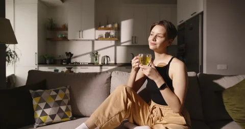 Woman enjoys free time, sitting on sofa ... | Stock Video | Pond5