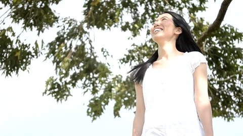 Woman in front of a shaking tree | Stock Video | Pond5