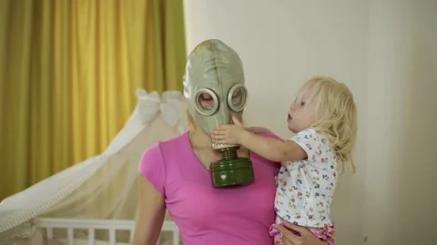 A woman in a gas mask, with a baby, hold... | Stock Video | Pond5