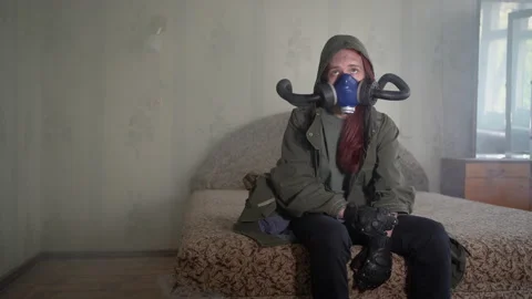 A woman in a gas mask sitting an post-ap... | Stock Video | Pond5