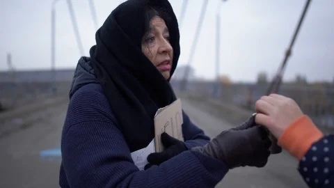 Woman gives alms to a beggar standing on... | Stock Video | Pond5