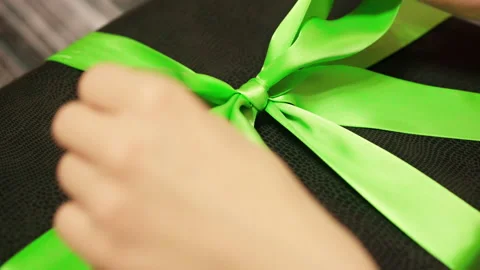 Woman hands untie green ribbon on black ... | Stock Video | Pond5