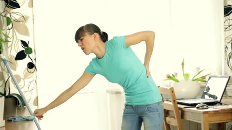 Woman having back pain during cleaning f... | Stock Video | Pond5